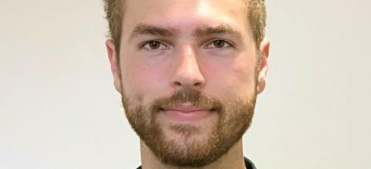 Indoor photo of white man in black collared shirt